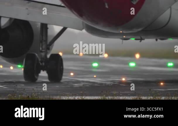 Close-up view of aircraft landing gear and engine on runway during heavy rain Stock Video ...