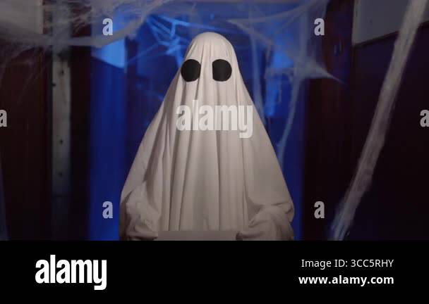 Funny halloween ghost in white sheet showing inscription boo on paper ...