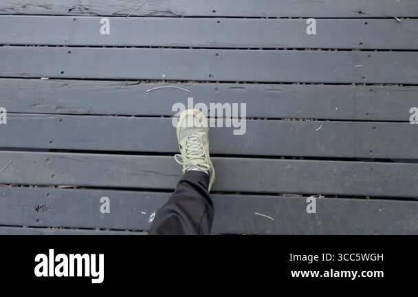 Person walking on wooden deck in gardens Stock Video Footage - Alamy