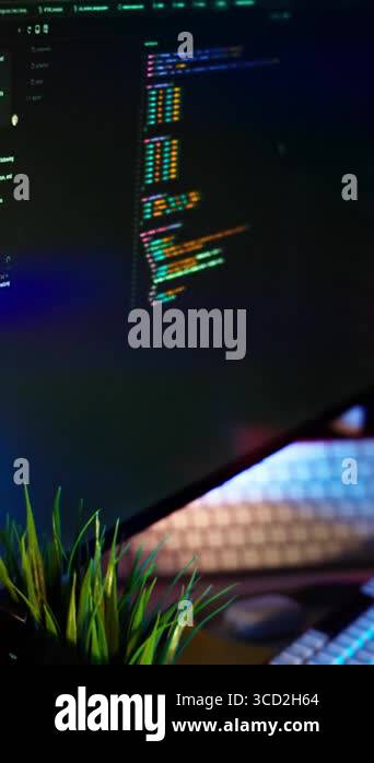 Programmer workspace code monitor setup with colorful source code on dark screen. Clean tech ...