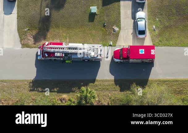 Paramedics assist patient at suburban home as ambulance and fire engine ...
