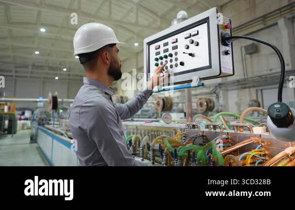 Factory worker operating advanced control panel with touchscreen ...