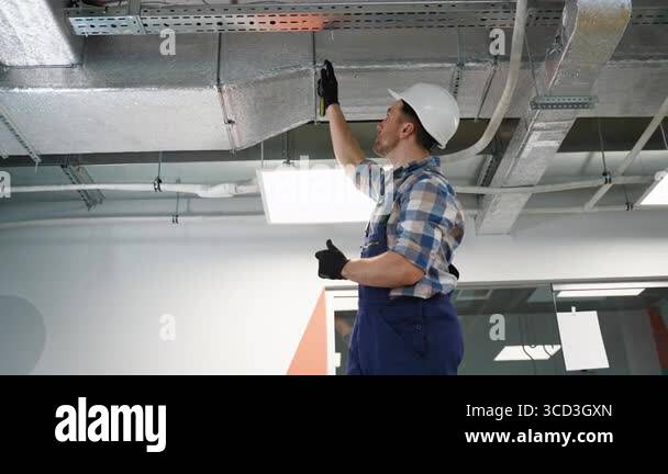 Professional hvac service worker examining insulation of air ducts ...