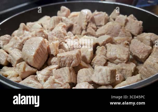 A close-up of cubed pork chunks in a pan, ready for cooking. the raw ...