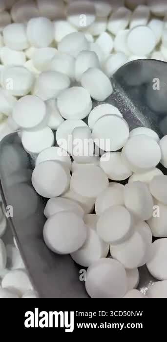 pile of assorted white round tablets, elongated capsules, and ...