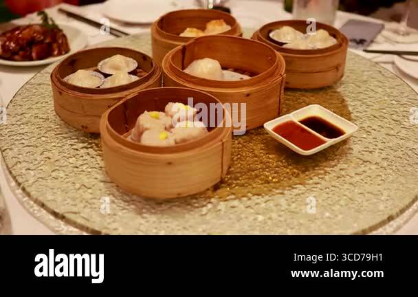 A variety of dim sum in bamboo steamers on a rotating table with ...