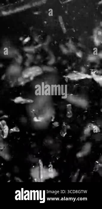Super slow motion of gunshot through the glass , shattering against ...