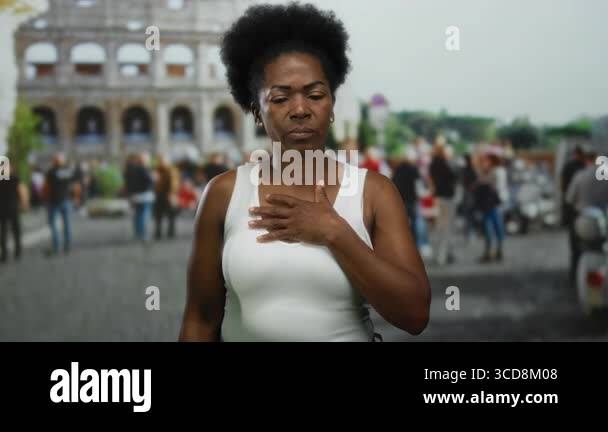 Woman standing near iconic roman coliseum looking tired with hand on ...