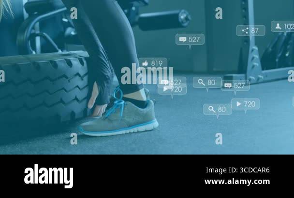 Female athlete gripping tractor tire on gym floor activating engagement ...