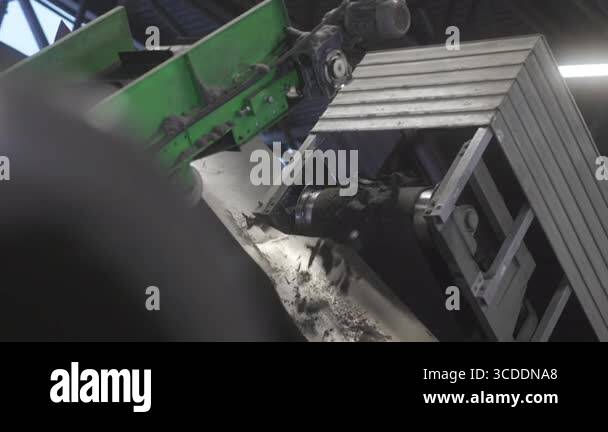 Crushed rubber chunks fall into metallic chute. Vibration carries ...