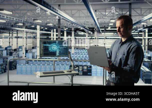 Engineer in data center checks AI dashboard using laptop during routine systems review. IT ...