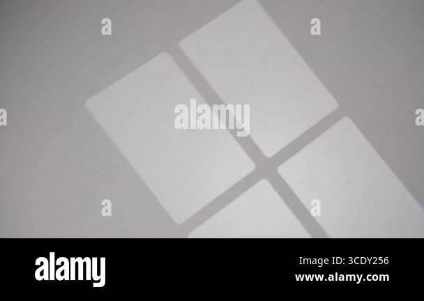 Bright sunlight casts clear rectangular shadow patterns on a clean ...