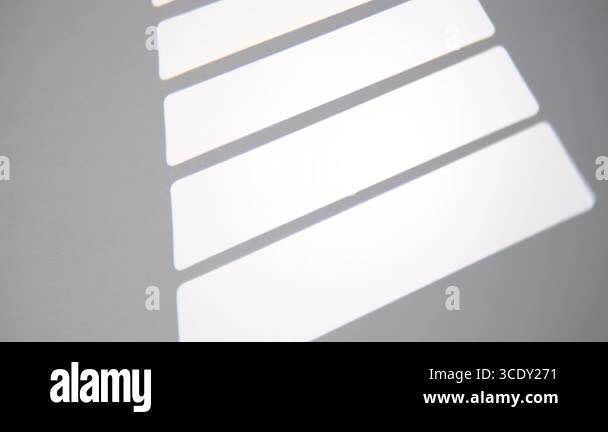 Natural sunlight creates beautiful striped shadow patterns on a light ...