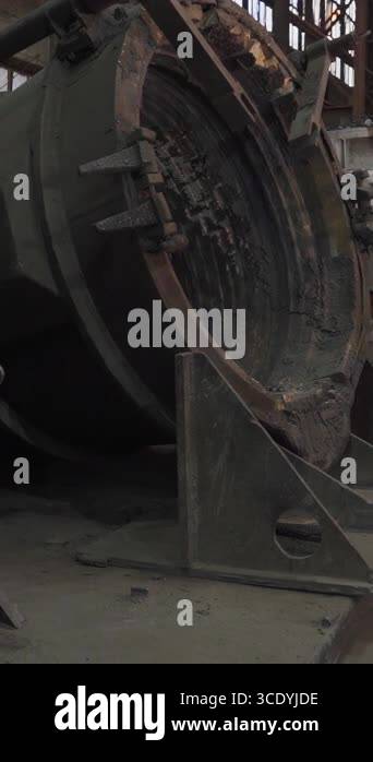 Foundry workers pouring molten metal into molds using heavy machinery ...