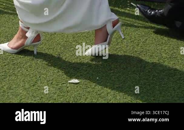 A detailed closeup of chic and stylish white high heels being elegantly ...