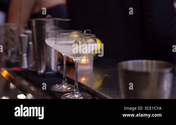 A skilled bartender artfully pours a delightful cocktail into elegant ...