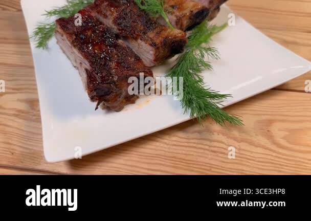 Sliced baked pork ribs portion on plate on rustic table Stock Video ...
