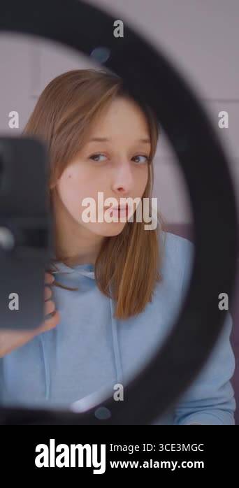 Young woman influencer is recording a video blog about cosmetics, showing makeup techniques and ...