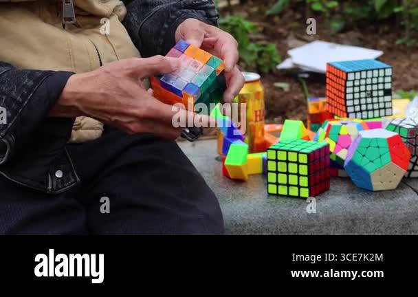 Man solving Rubik's Cube among various puzzles Stock Video Footage - Alamy