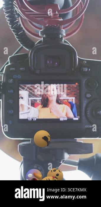 Animation of emoji icons over female vlogger on camera viewer recording ...