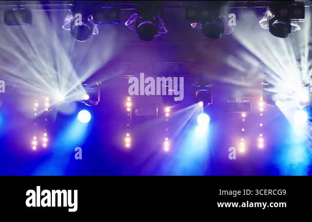 Stage with bright concert lighting, spotlights and smoke effects ...