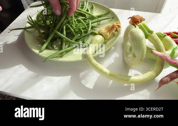 Woman take pink bean pods from colander. Healthy food and vegetables ...