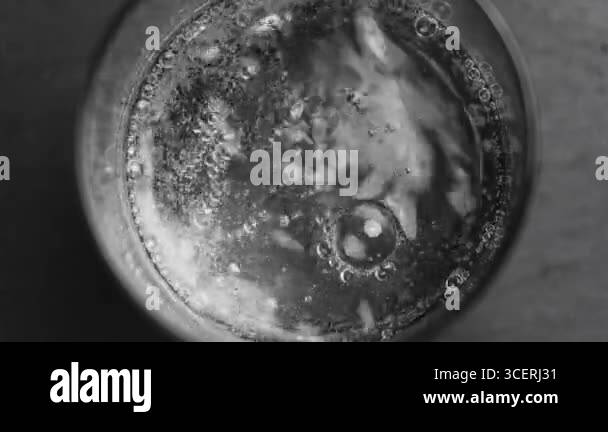 Sparkling fizzy carbonated water in glass on black dark table with ...