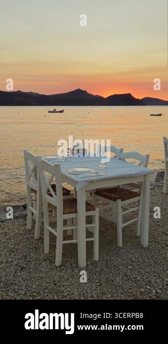 A beautifully set table for two at a waterfront restaurant awaits ...