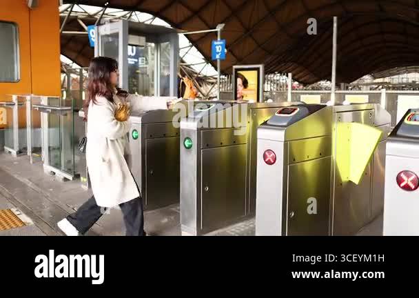 Woman uses ticket to pass through turnstile Stock Video Footage - Alamy