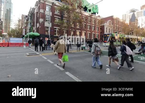 People crossing street with tram passing by Stock Video Footage - Alamy