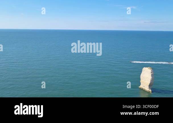 Vast ocean scene featuring majestic cliffs against a clear blue sky. a ...