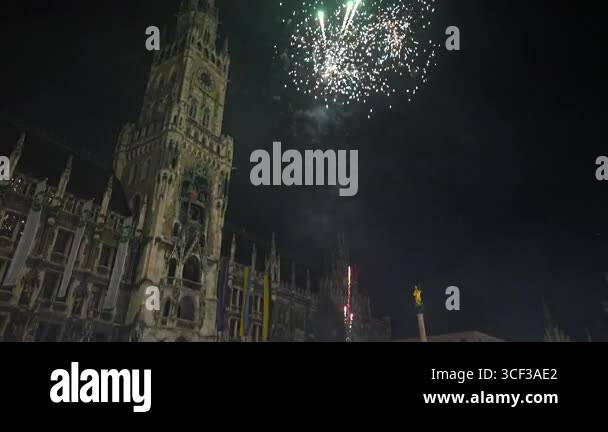 Gothic Rathaus tower in Munich with fireworks lighting up night sky ...