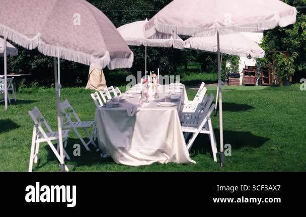 Table neatly set up outside for guests during a wedding reception on a ...