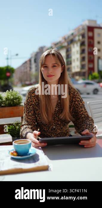 Beautiful blonde woman in casual shirt closing tablet after enjoying ...