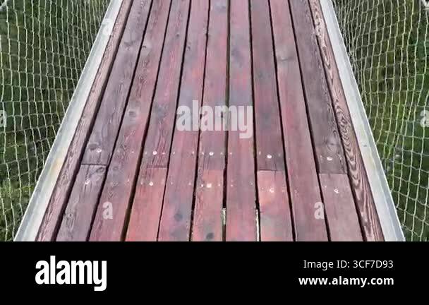 Suspension bridge spanning valley, picturesque mountain village ...