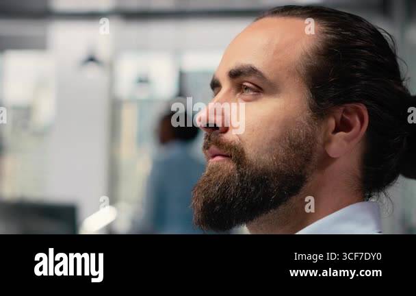 Trader in office looking upward with subtle smile on face, visualizing ...