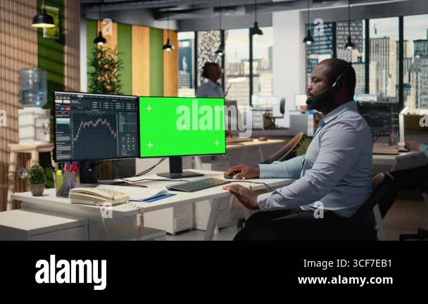 Investment consultant talking in headset mic, using green screen PC ...