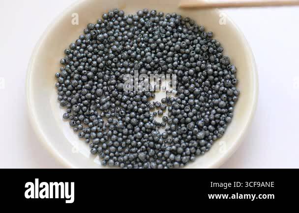 Iodine crystals (granules) at the white dish Stock Video Footage - Alamy