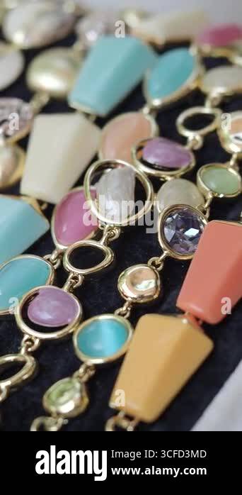 Gems of various shapes and colors are showcased elegantly on a dark ...