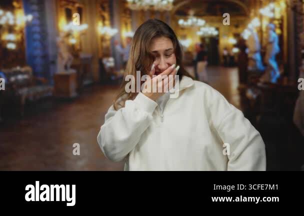 Woman laughing indoors in a museum with a thoughtful expression ...