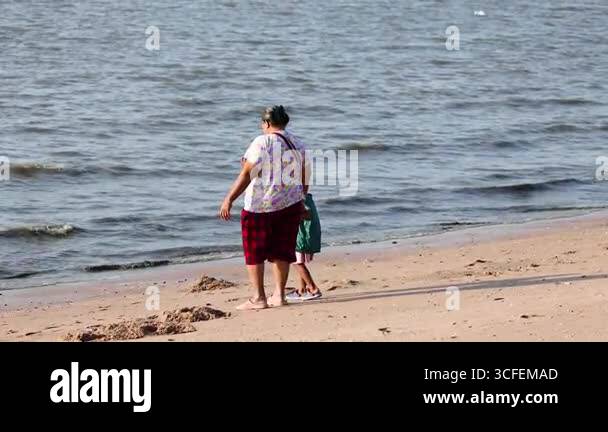 Person walking on sandy beach by the sea Stock Video Footage - Alamy