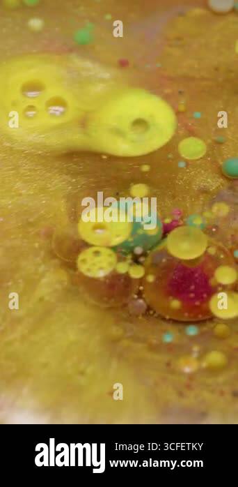 Vertical video. Glitter flow. Bubble burst. Color shimmering golden ...