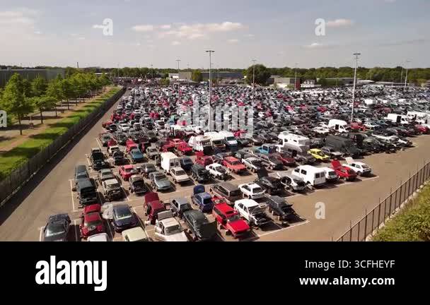 An extensive collection of vehicles is lined up in an auto salvage yard ...