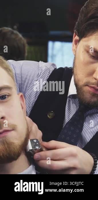 In a charming vintage barbershop, a skilled barber attentively trims ...