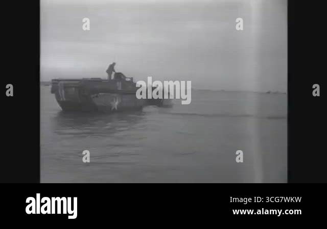 WONSAN - 1950 - An LVT drives towards a landing craft and a tow tractor ...