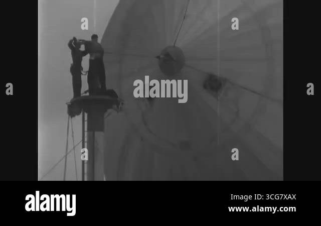 KEY WEST - 1954 - Two men attach a cable from the ZPG airship's nose to ...