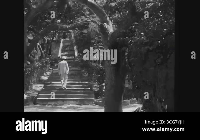 NASSAU - 1921 - Man walking up steps, through trees and garden ...