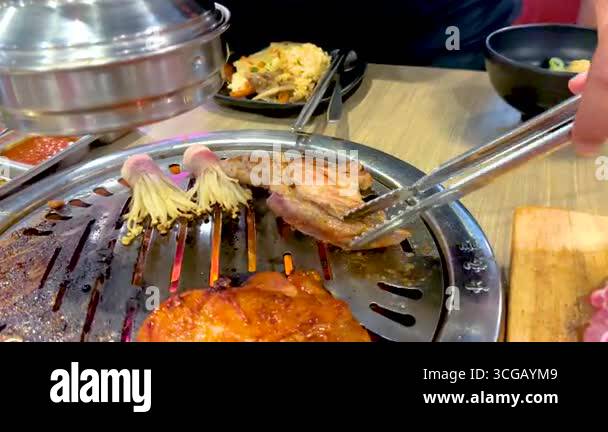 Grilled meat and mushrooms on a Korean BBQ grill in a Bangkok ...