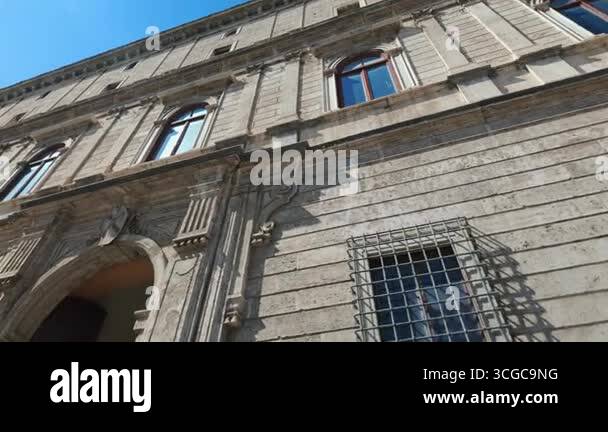 Low-angle view of historic European stone building with arched doorway ...