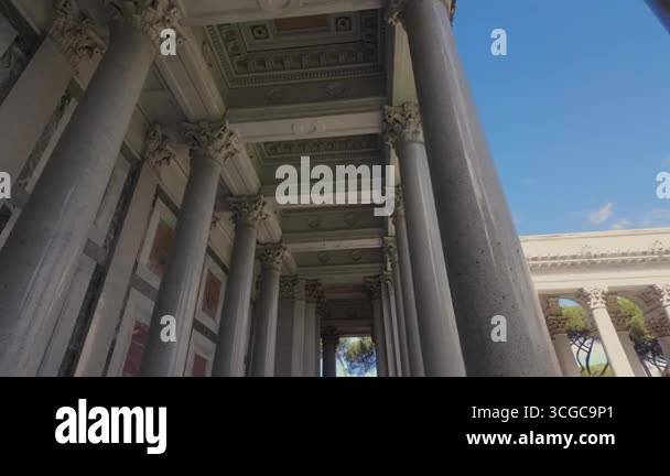 Row of tall stone columns with ornate capitals supporting decorated ...